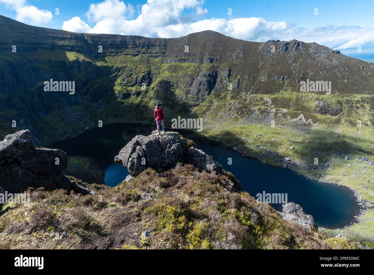 Woman mountaineer admiring the Coumshingaun lake Stock Photo - Alamy