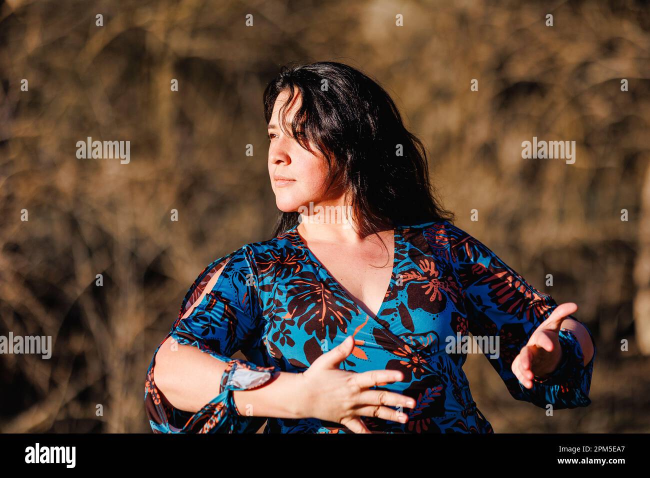 Woman in golden light with intense expression looking into distance ...