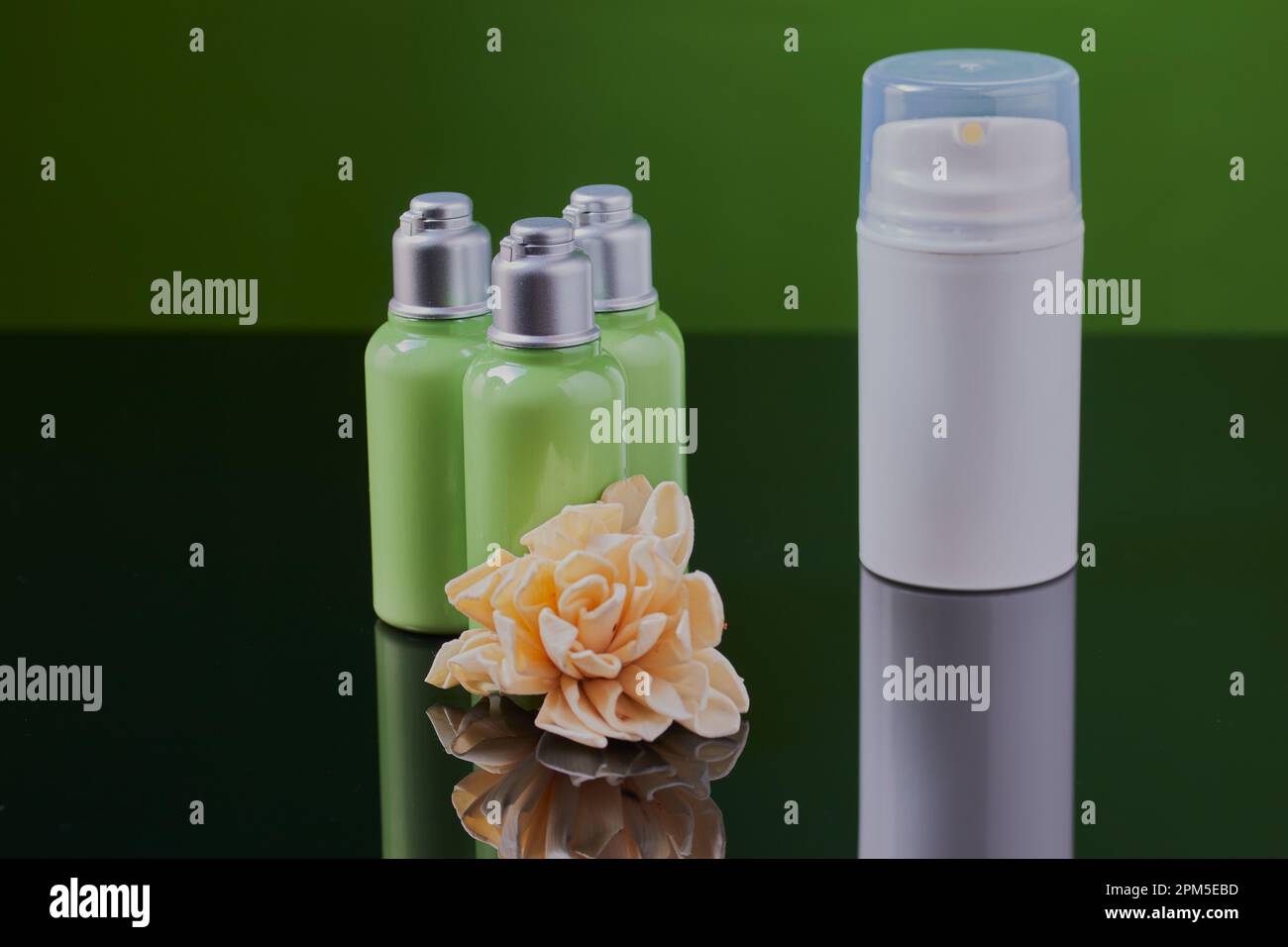 Bathroom Soaps And Moisturiser On A Reflective Surface With A Green