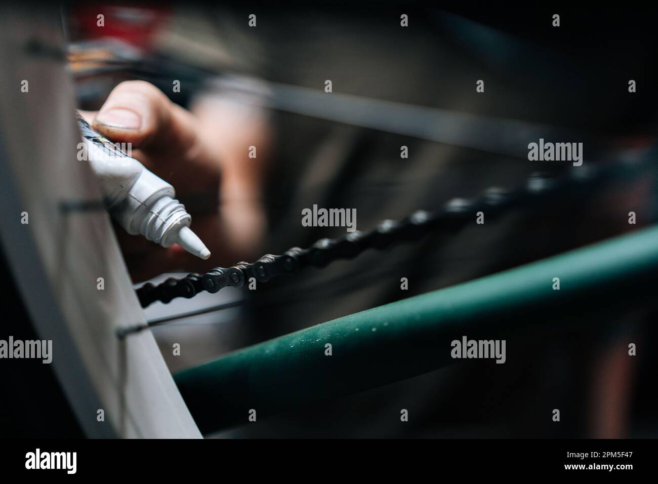 Detail cropped shot of unrecognizable man greasing, oiling, lubricating ...