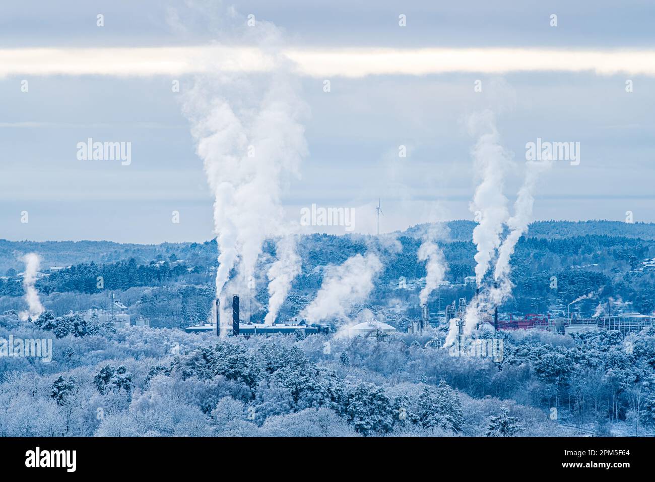 Steam rising from industry behind a forest Stock Photo - Alamy