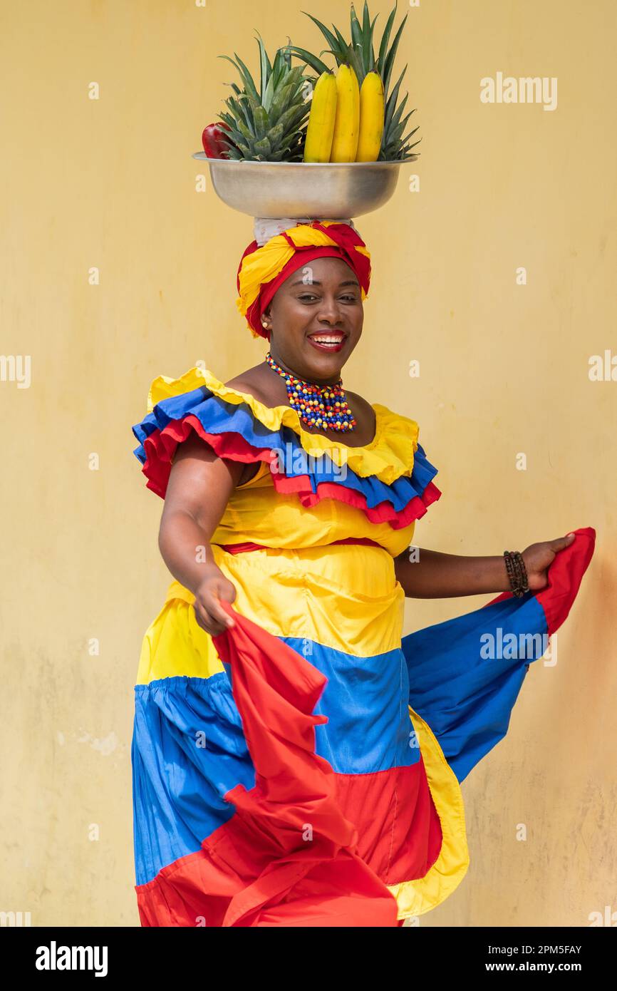 Happy smiling Palenquera fresh fruit street vendor dancing in Cartagena ...