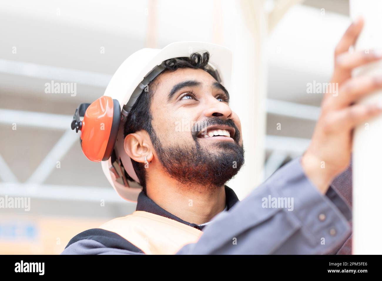 young technician safety vest and helmet working Stock Photo - Alamy