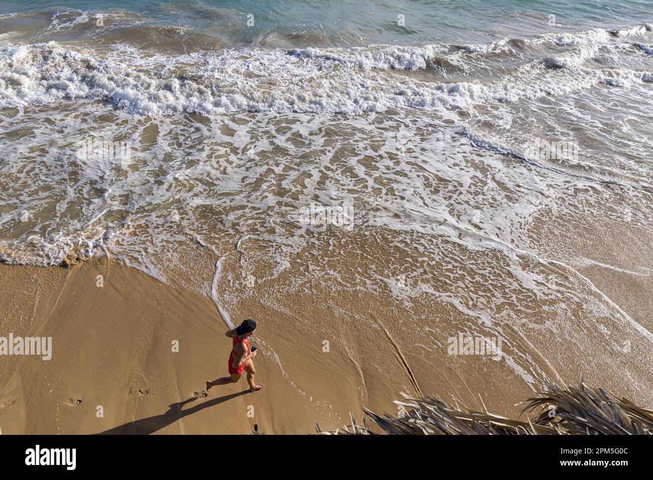 overhead view of woman running on beach with waves Stock Photo - Alamy