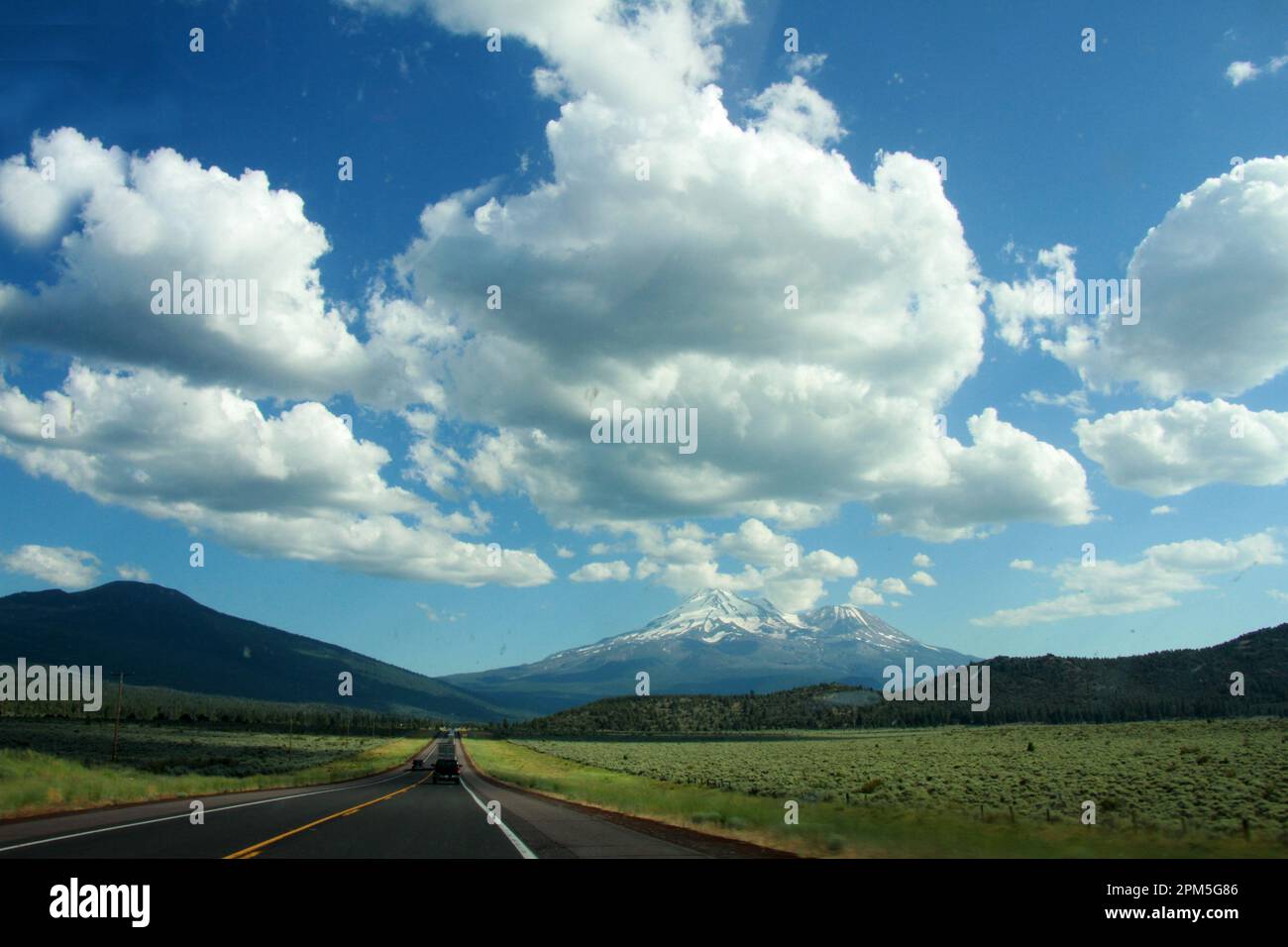 View of Mount Shasta and Big Clouds from Stretch of Road Stock Photo ...