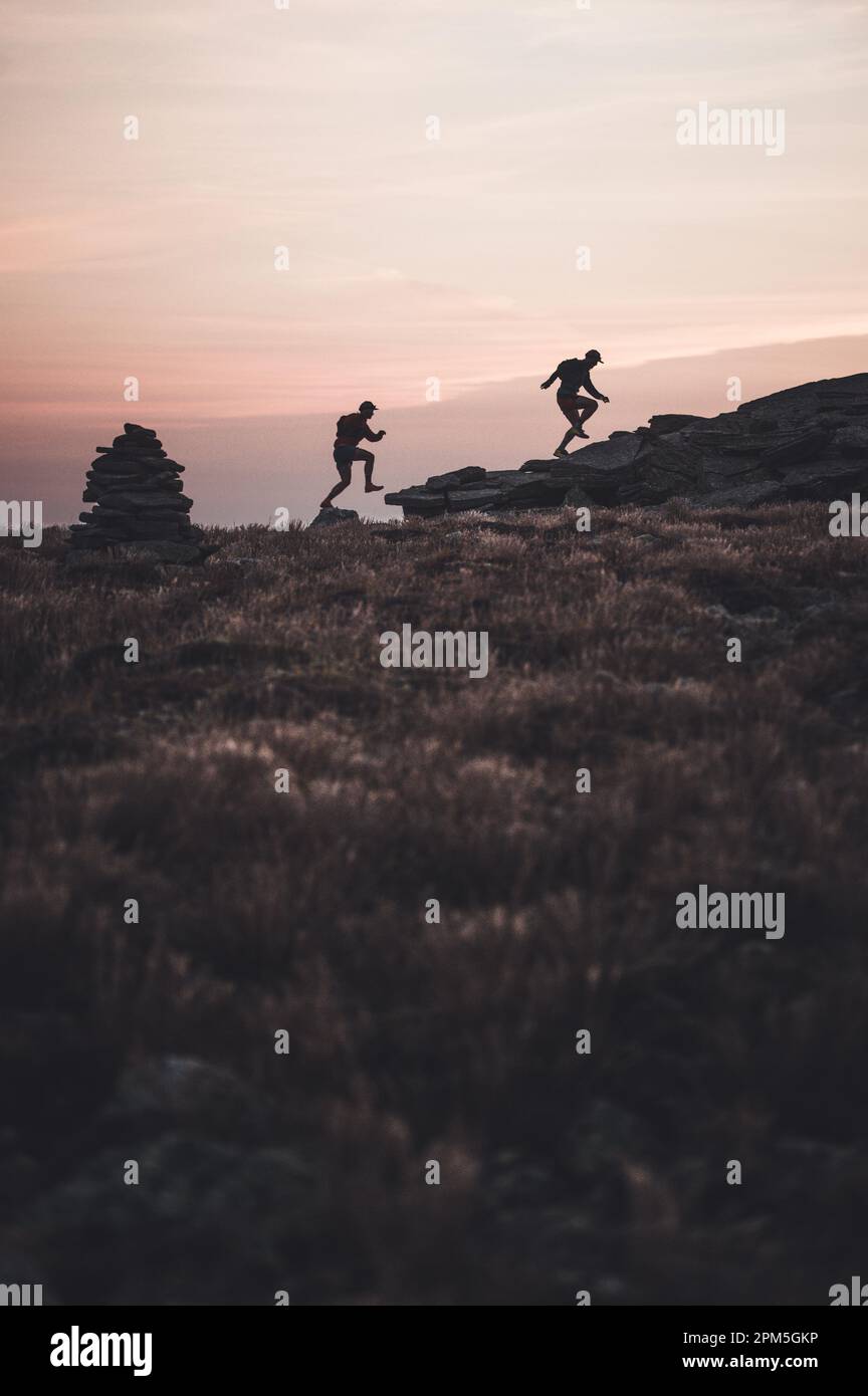 Silhouette male trail runners running over ridge at dawn sunrise Stock ...