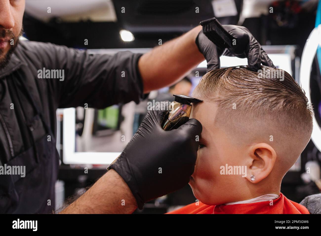 Adult male barber lining up child's edges in Portland, Oregon Stock ...