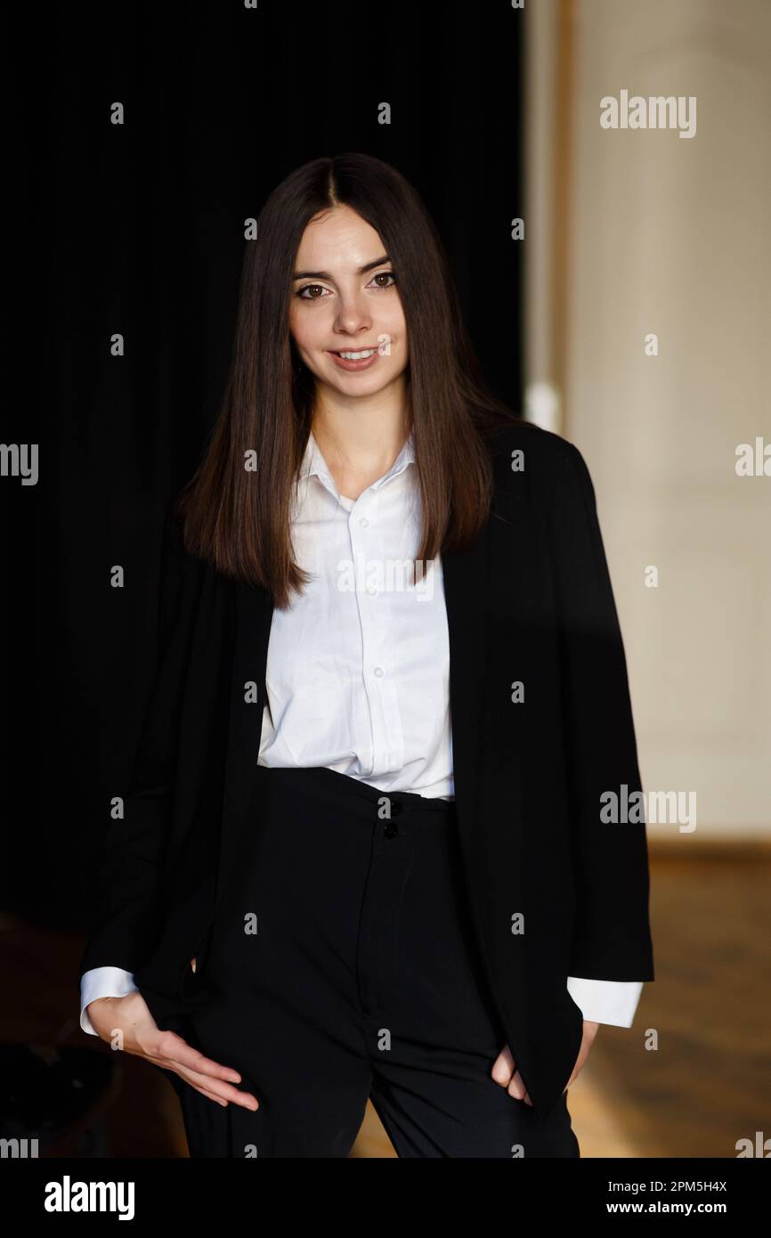 an actress in white shirt and black suit in rehearsal hall of theater ...