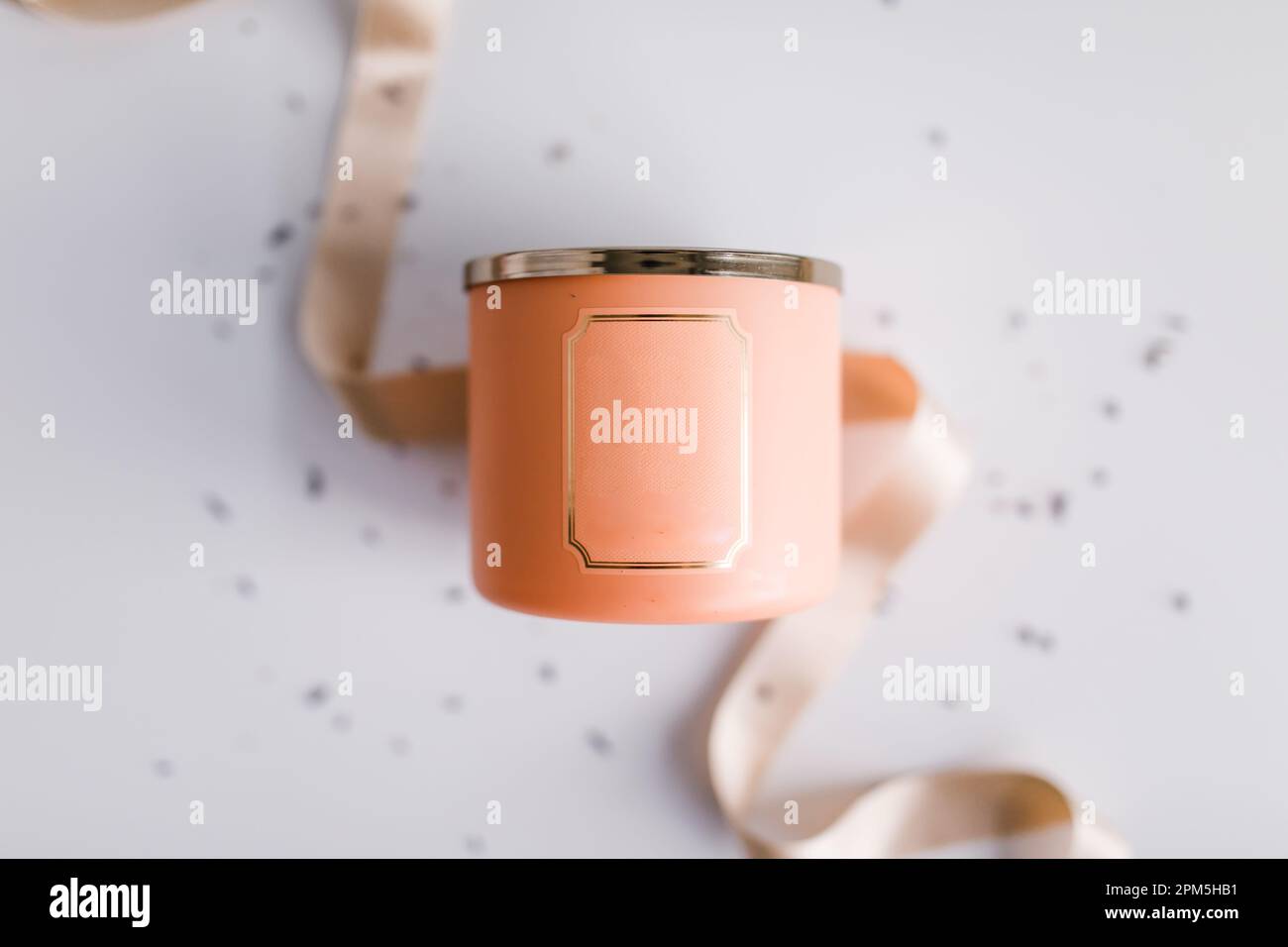 Peach colored candle in focus with ribbon and sprinkles Stock Photo - Alamy