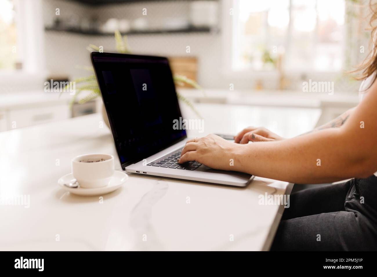 Side view of a woman working on computer with coffee inside Stock Photo ...