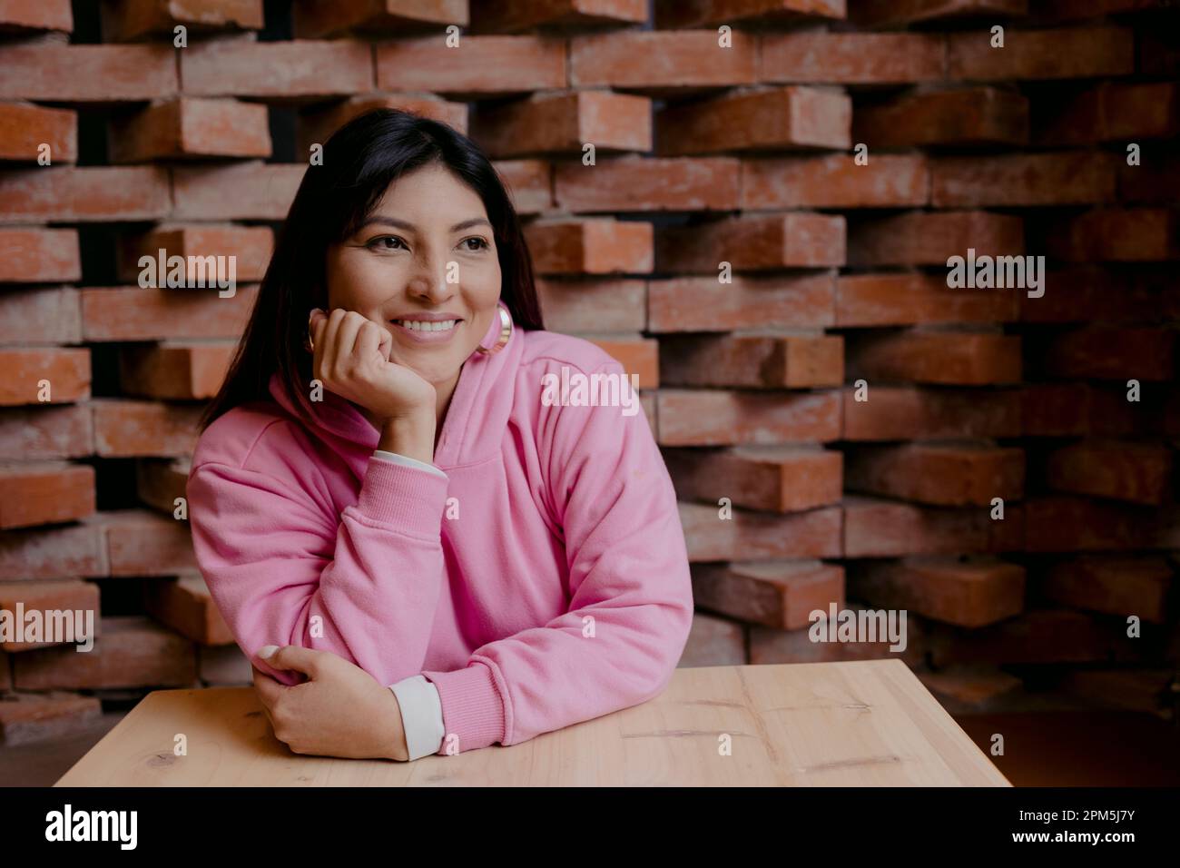 portrait of an hispanic woman smiling and thinking Stock Photo - Alamy