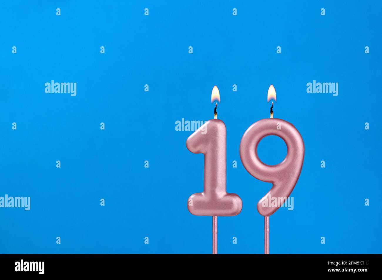 Number 19 - Burning anniversary candle on blue foamy background Stock ...