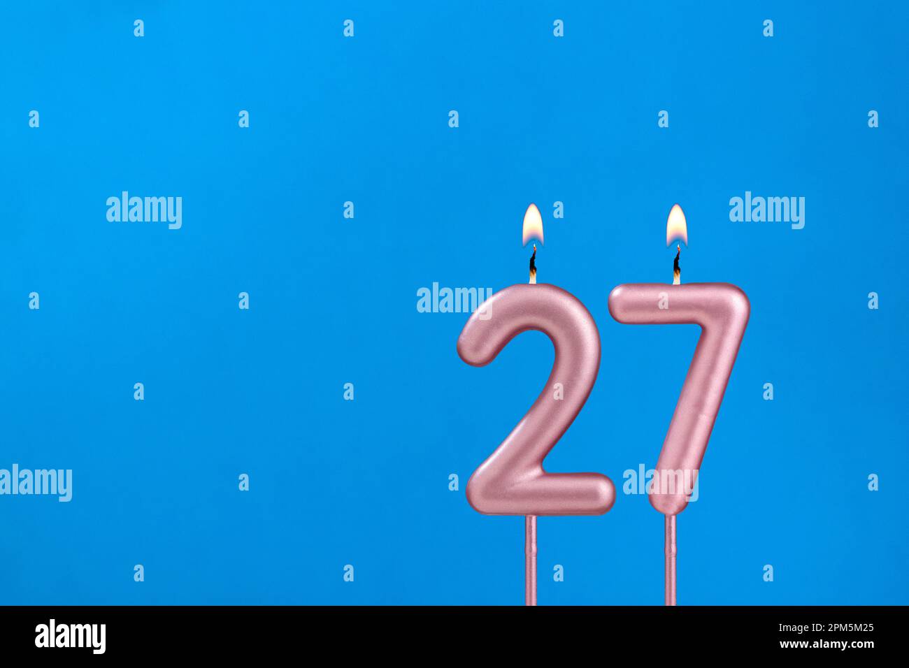 Number 27 - Burning anniversary candle on blue foamy background Stock ...