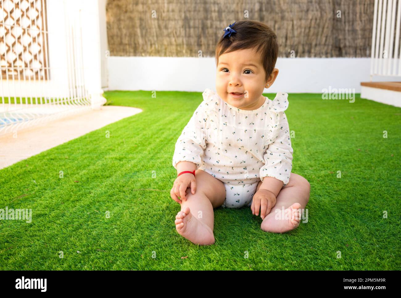 Adorable little baby girl with cute smile sitting unsupported and ...