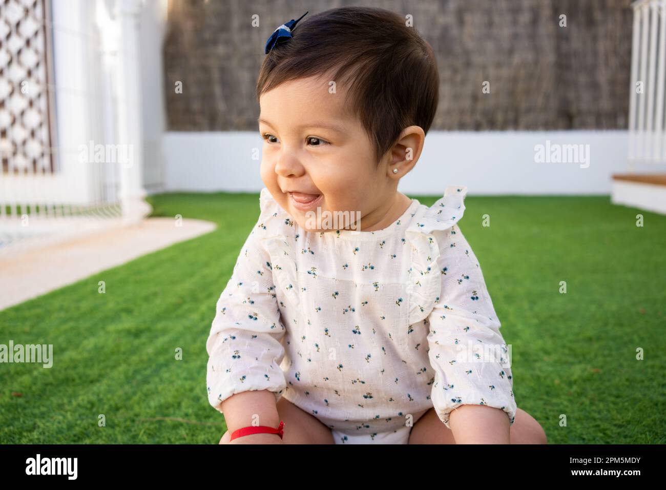 Adorable little baby girl with cute smile sitting unsupported and ...