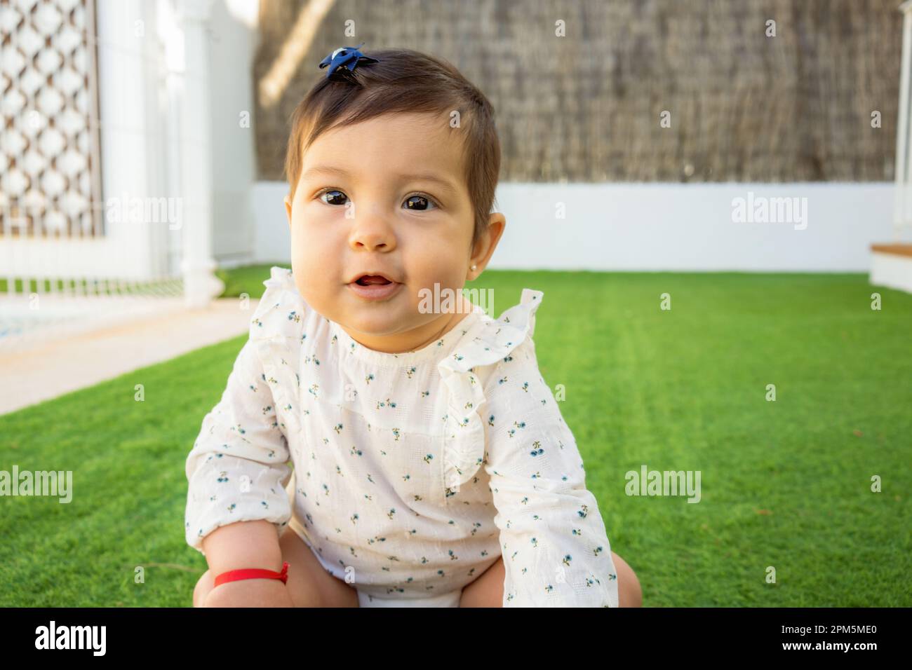 Adorable little baby girl with cute smile sitting unsupported and ...