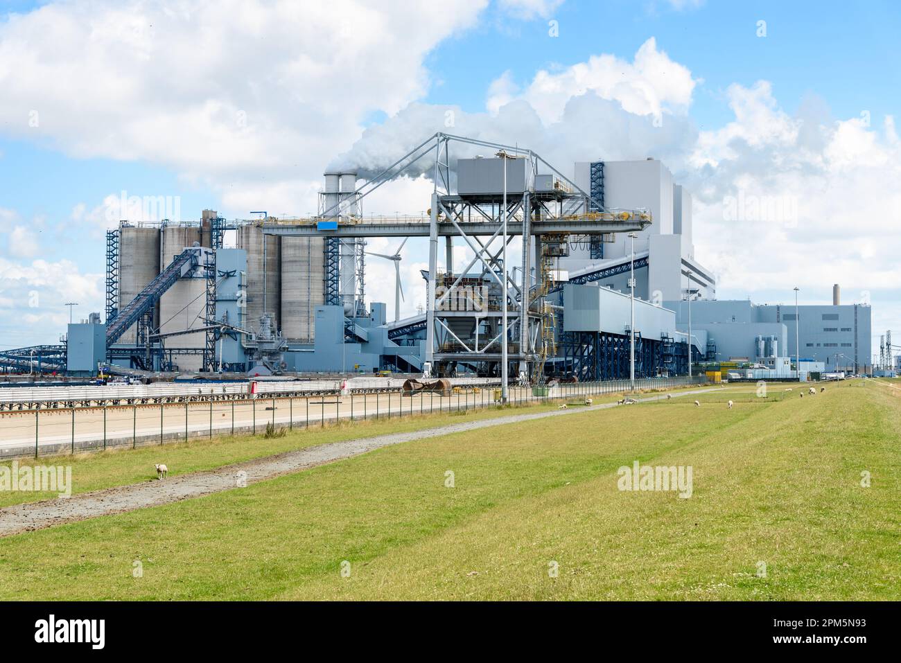Dockside coal fired power station on a partly cloudy summer day. Dense ...