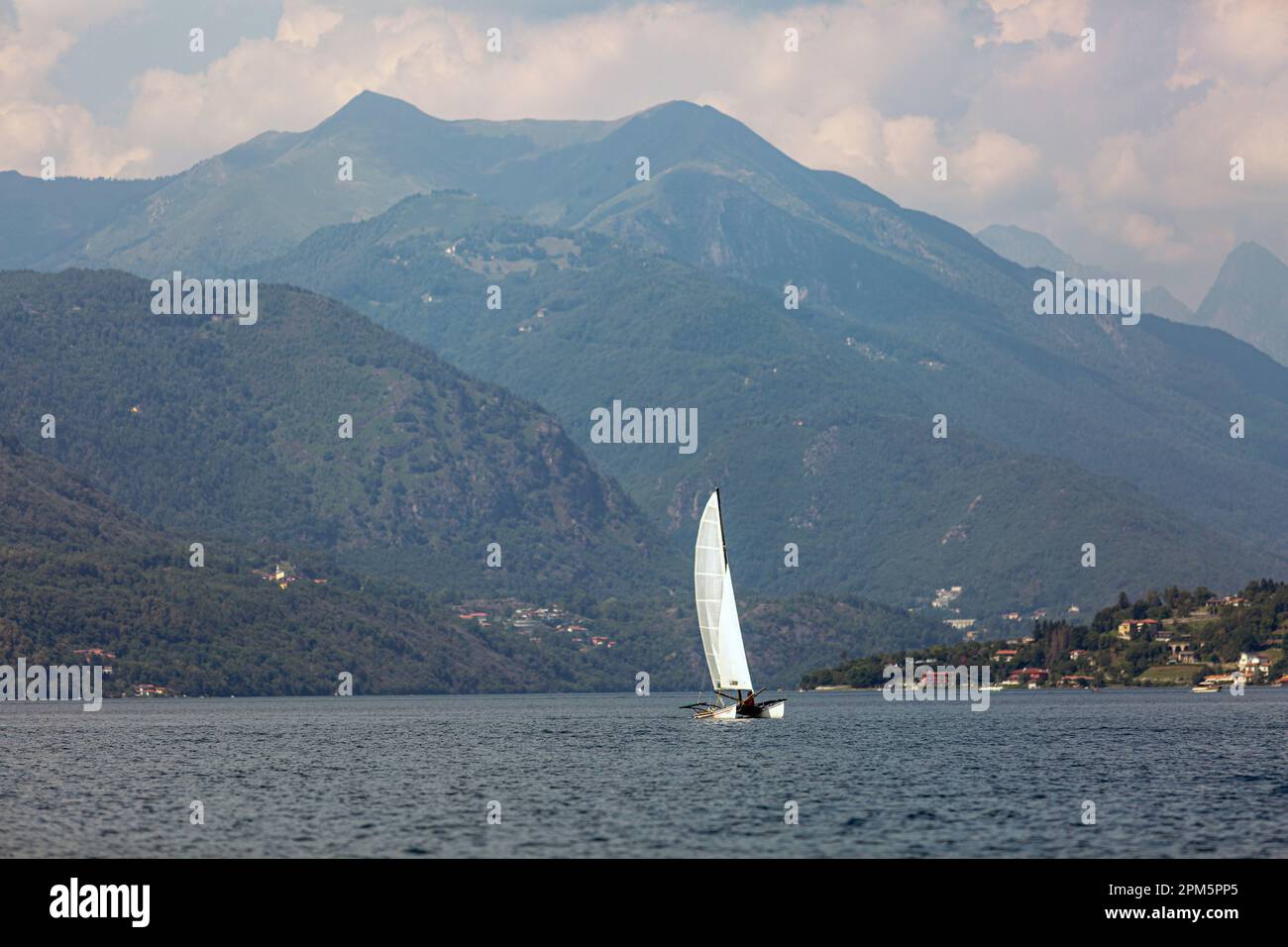 A white boat stands out against the deep blue water of Lake Como and ...