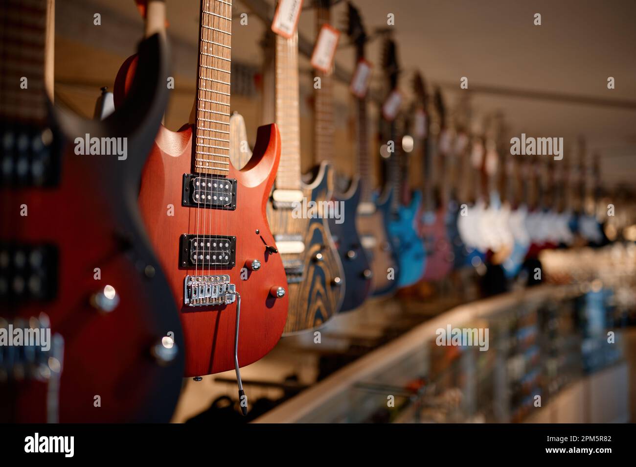Electric guitars on the rack in a row at modern musical showroom Stock ...