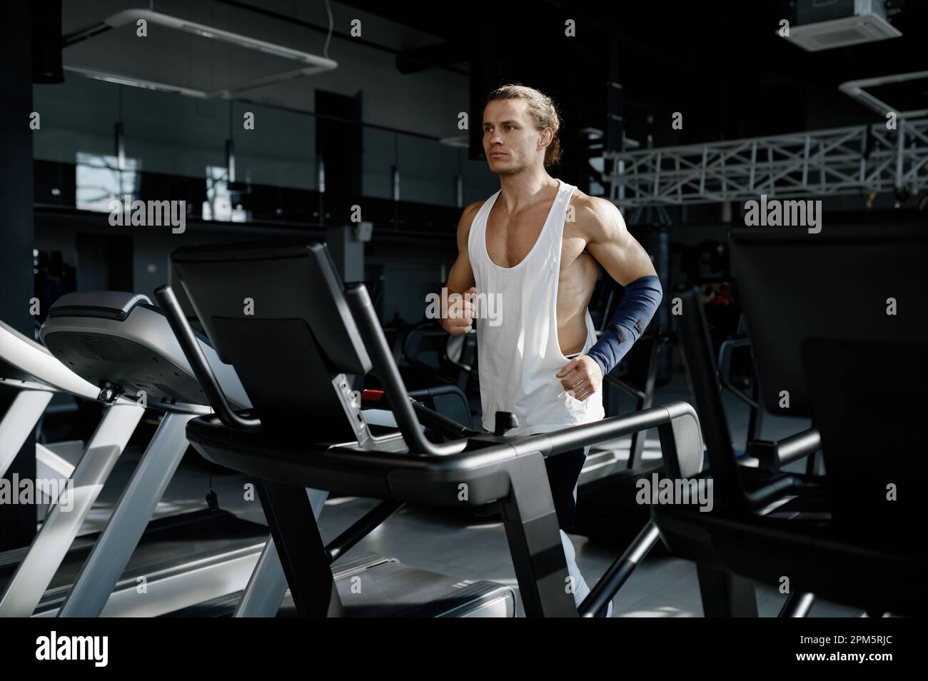 Strong muscular man running on treadmill at modern sport gym Stock ...