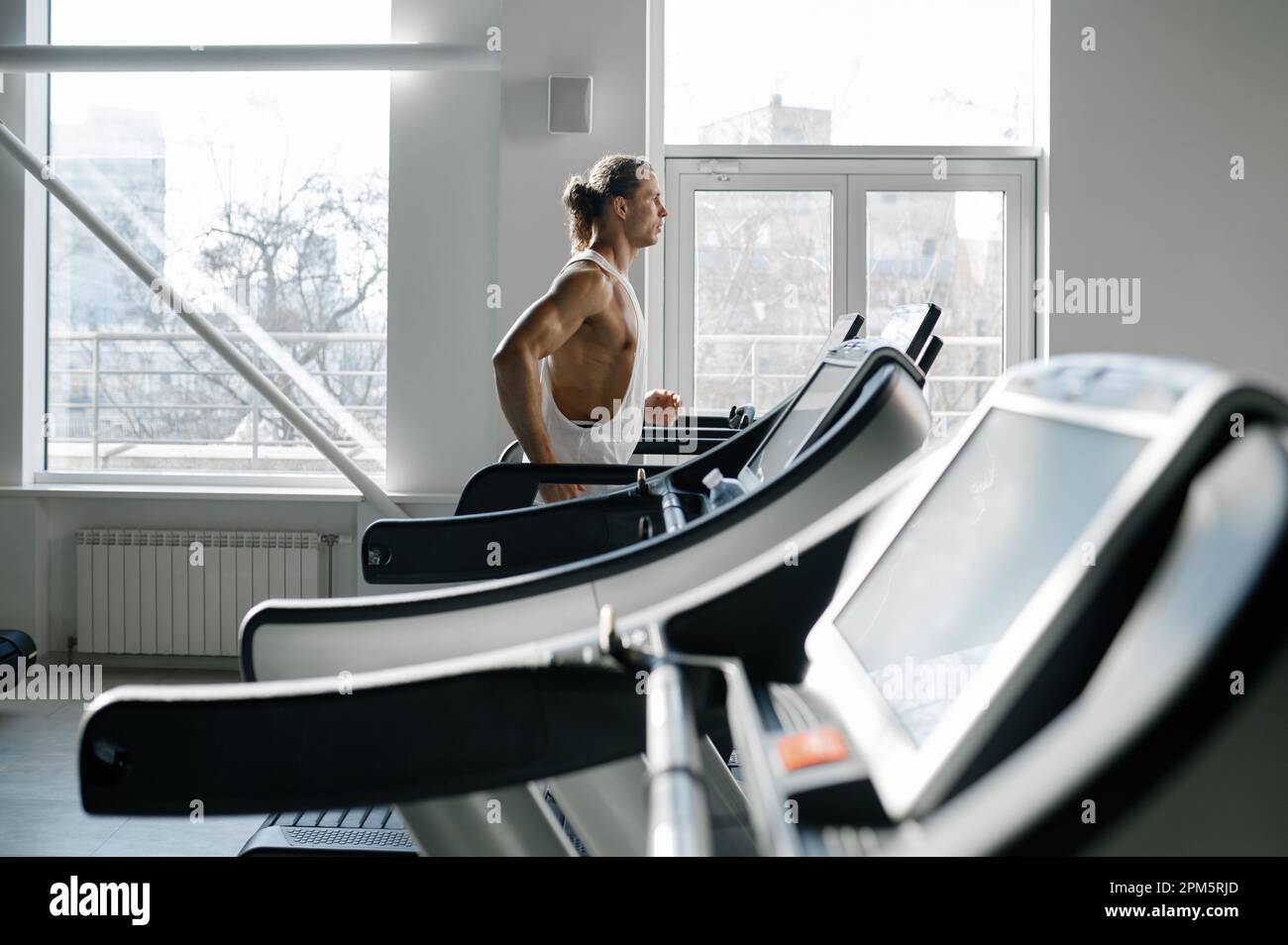 Strong muscular man running on treadmill at modern sport gym Stock ...
