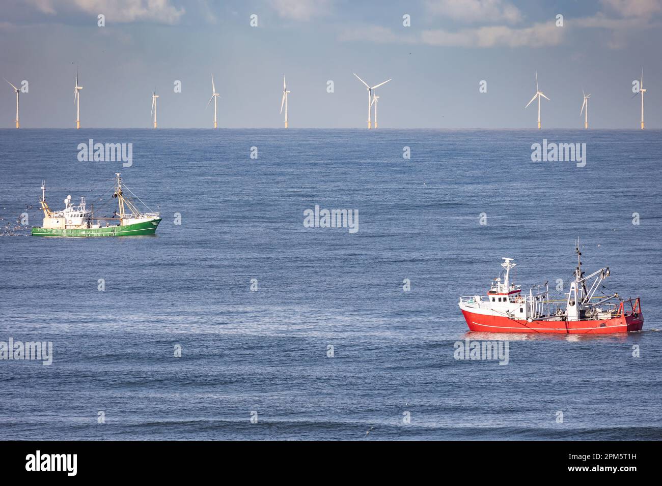 Two cutters passing each other in the North sea with wind turbines of a ...