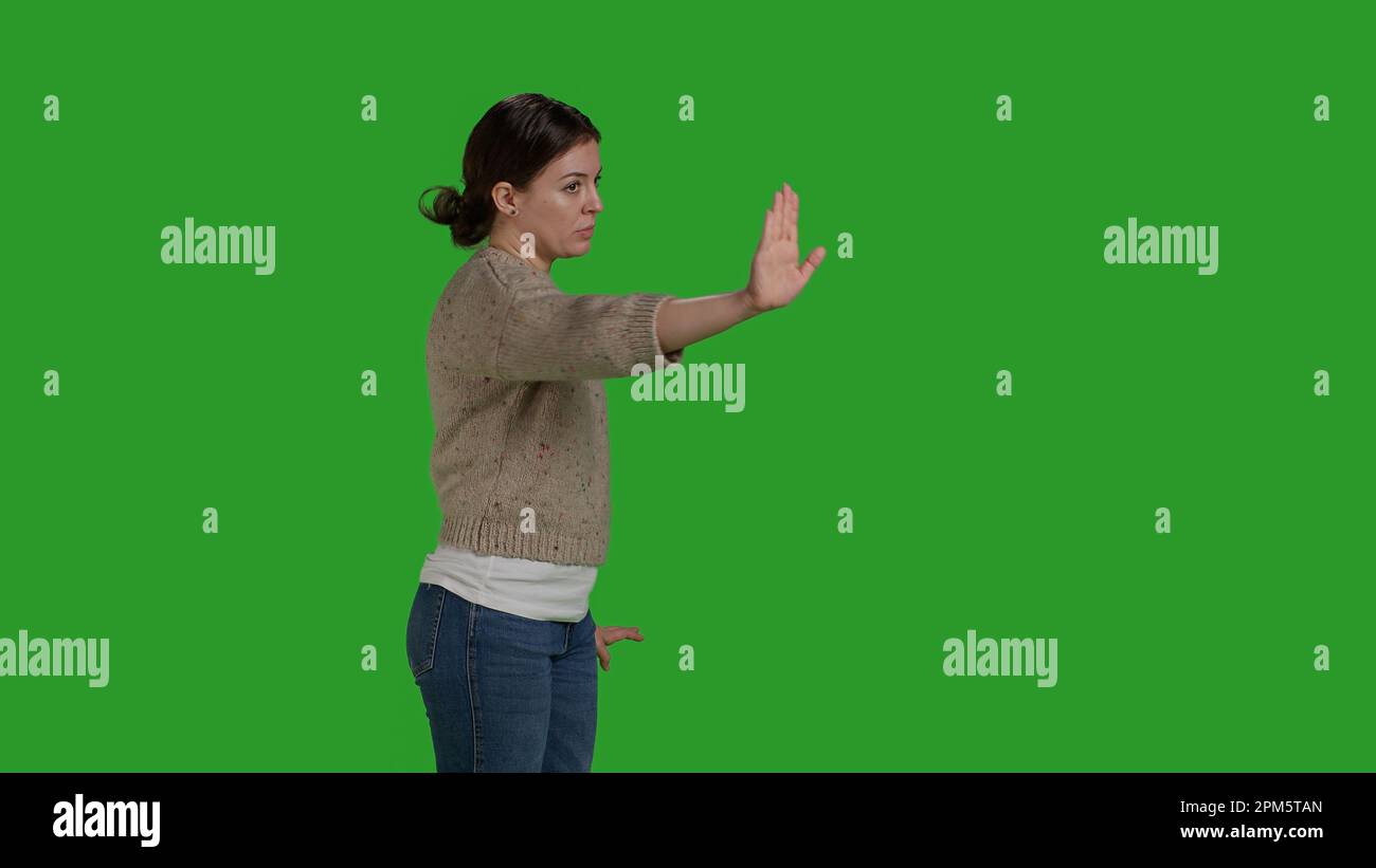 Side view of young woman raising palm as rejection gesture, expressing ...