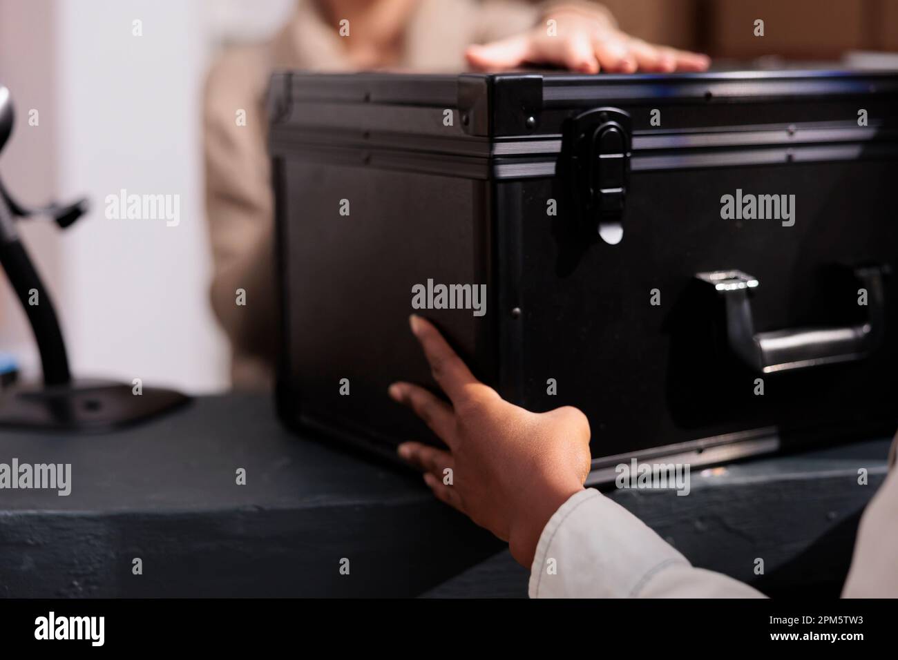 Retail store stockroom employee giving colleague black case at ...