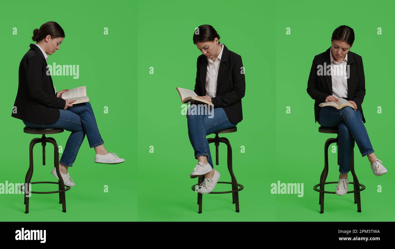 Focused businesswoman reading book sitting on chair in studio, read ...