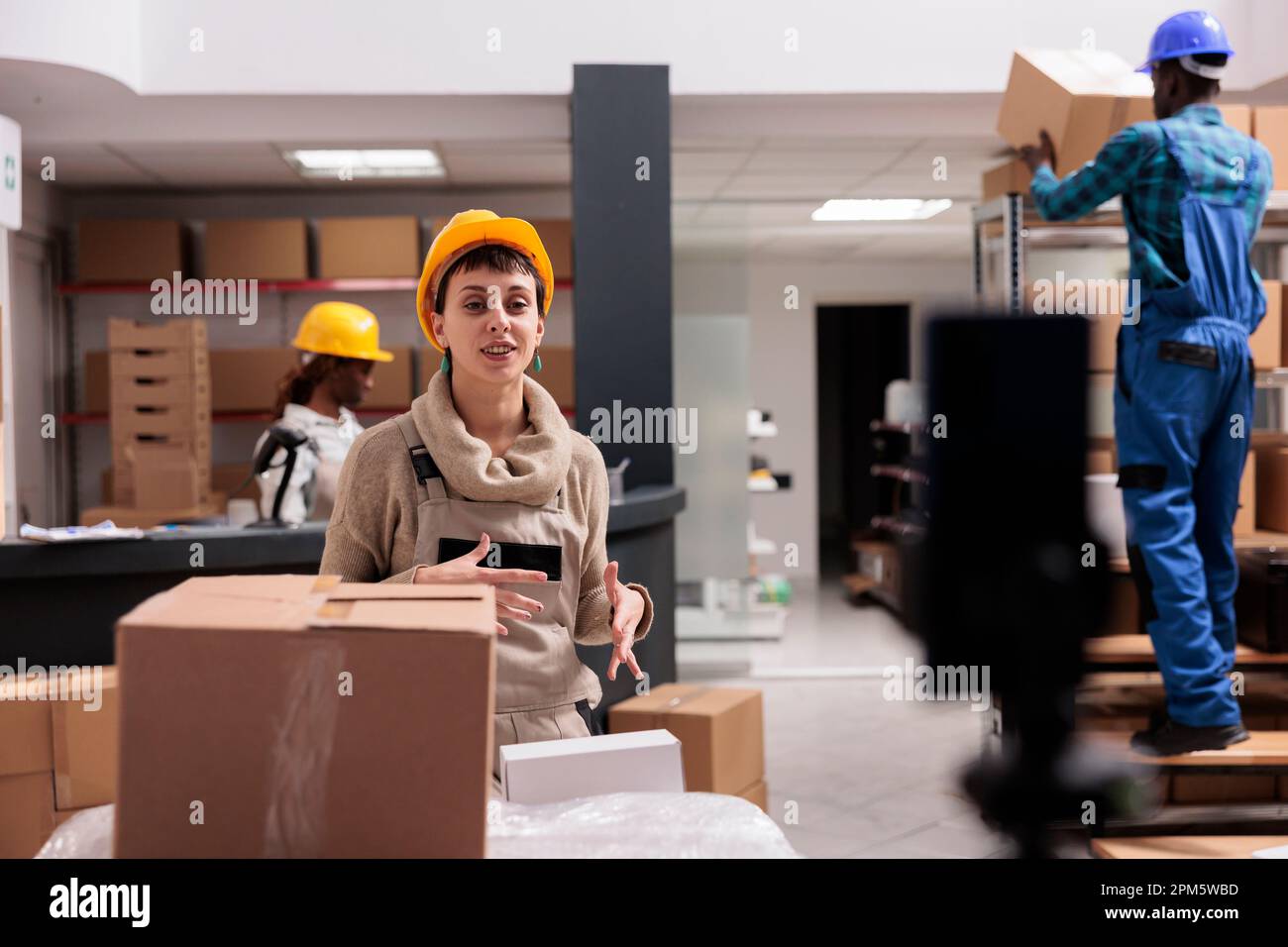 Storehouse worker recording smartphone video with inventory management ...