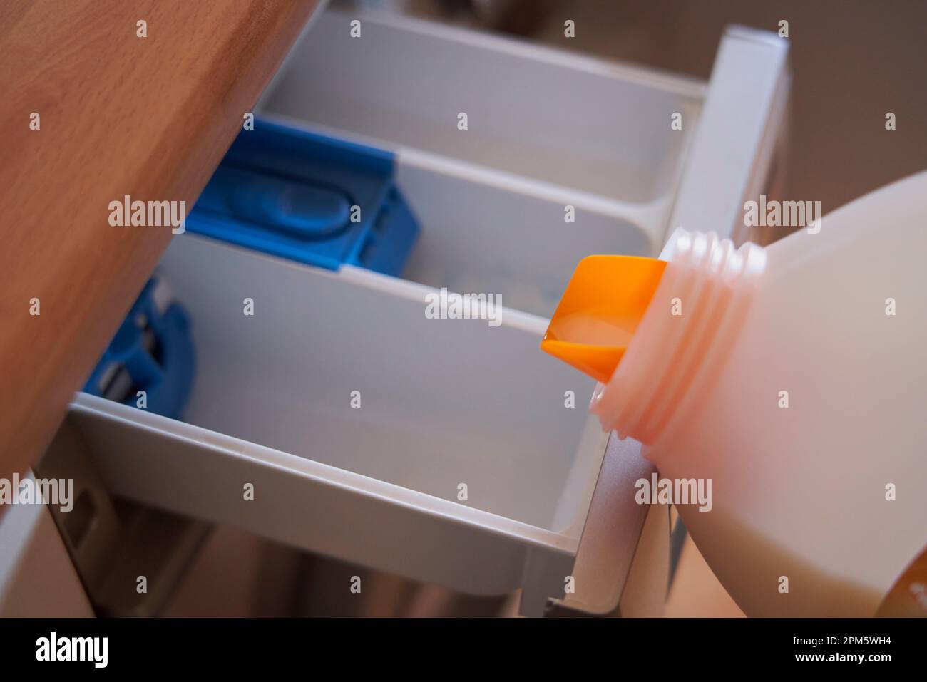 closeup pouring detergent into the compartment of a washing machine ...