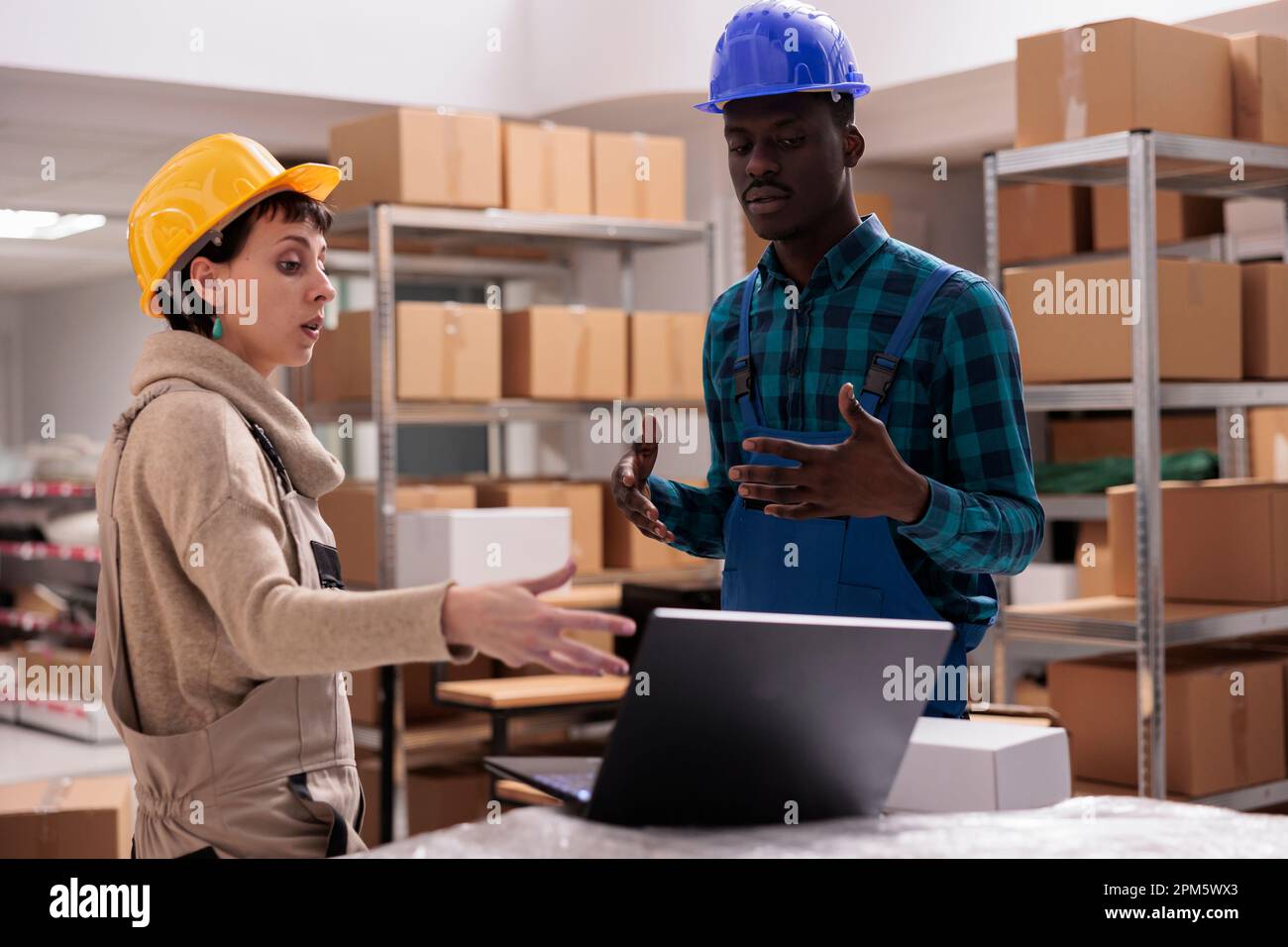 Retail warehouse managers team discussing orders list on laptop ...