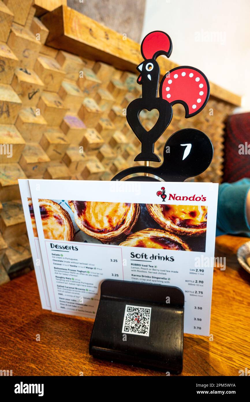 A menu in a menu holder on a table in a Nando's restaurant with the ...