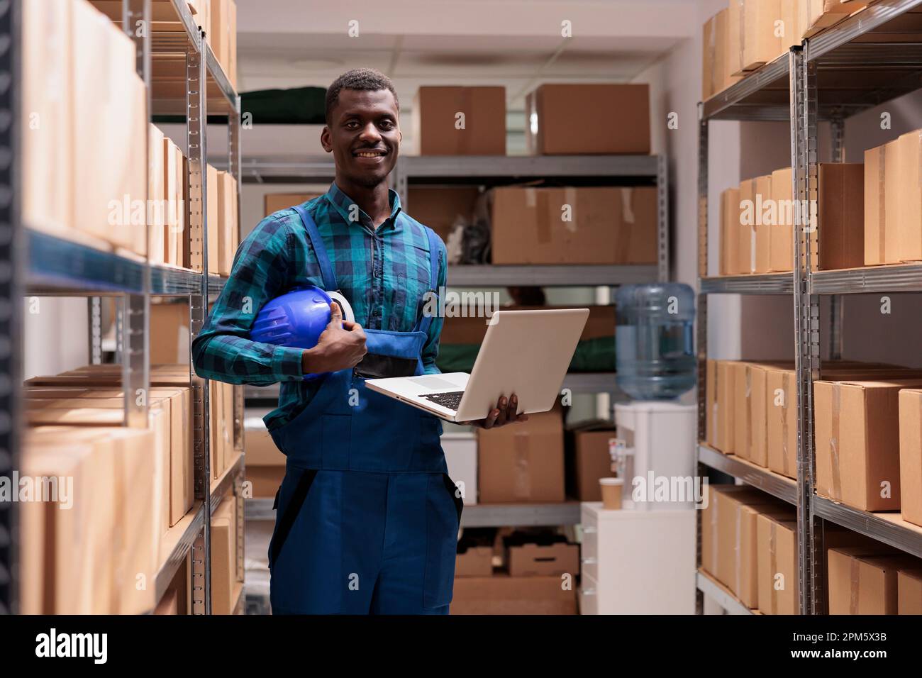 African american distribution center manager holding laptop in ...