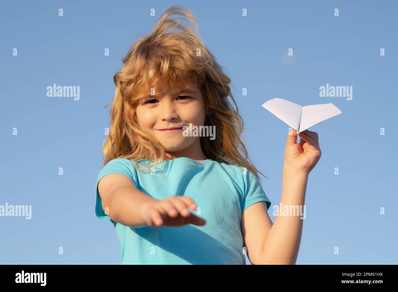 Origami paper airplane. Kid boy throwing a paper plane with blue sky ...