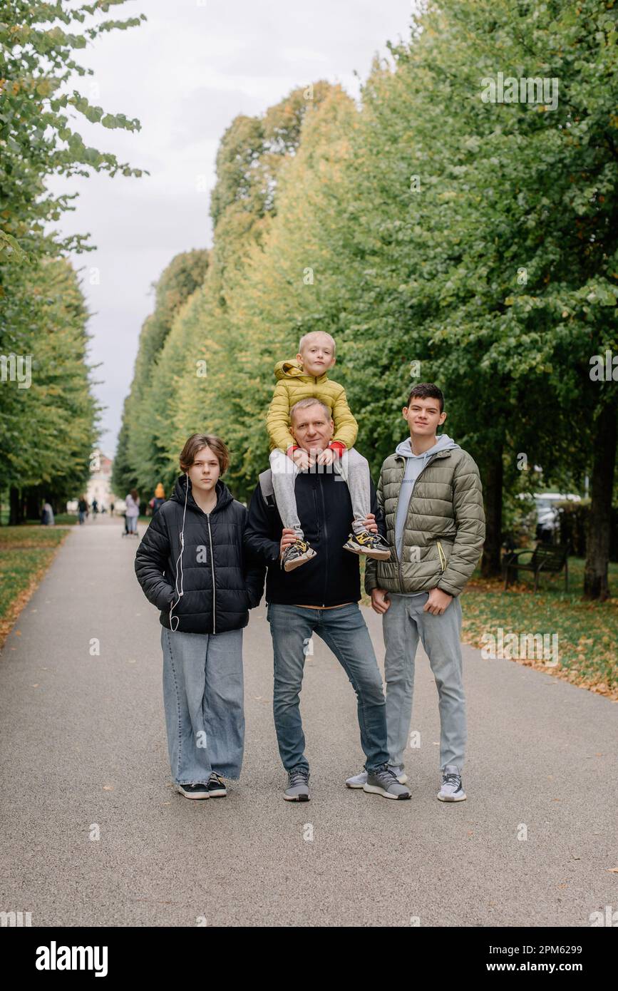 Happy family - Father with three children together in autumn park ...