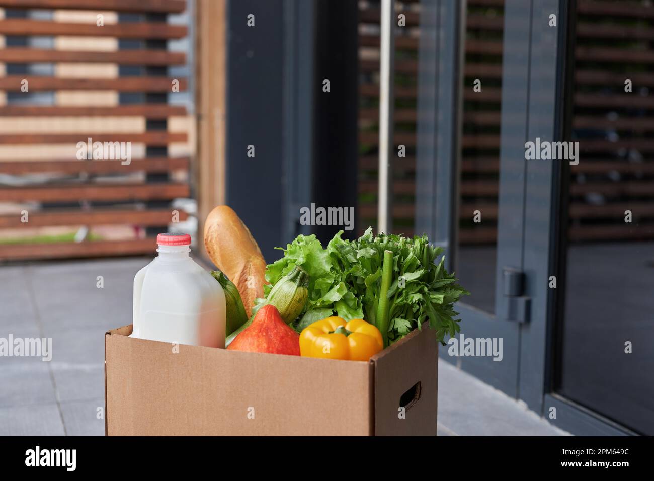 Closeup background image of box with fresh groceries outdoors on house ...