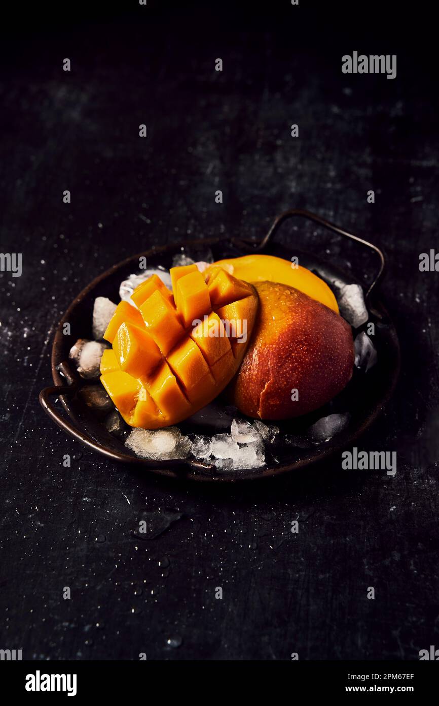 Fresh Mango on black tray and black background Stock Photo - Alamy