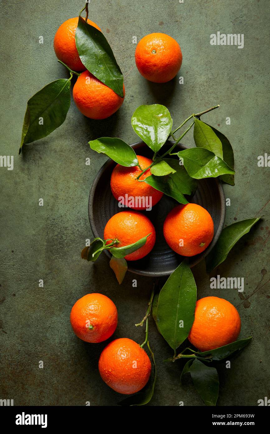 Stem & Leaf Mandarin Oranges on a Green Background Stock Photo - Alamy