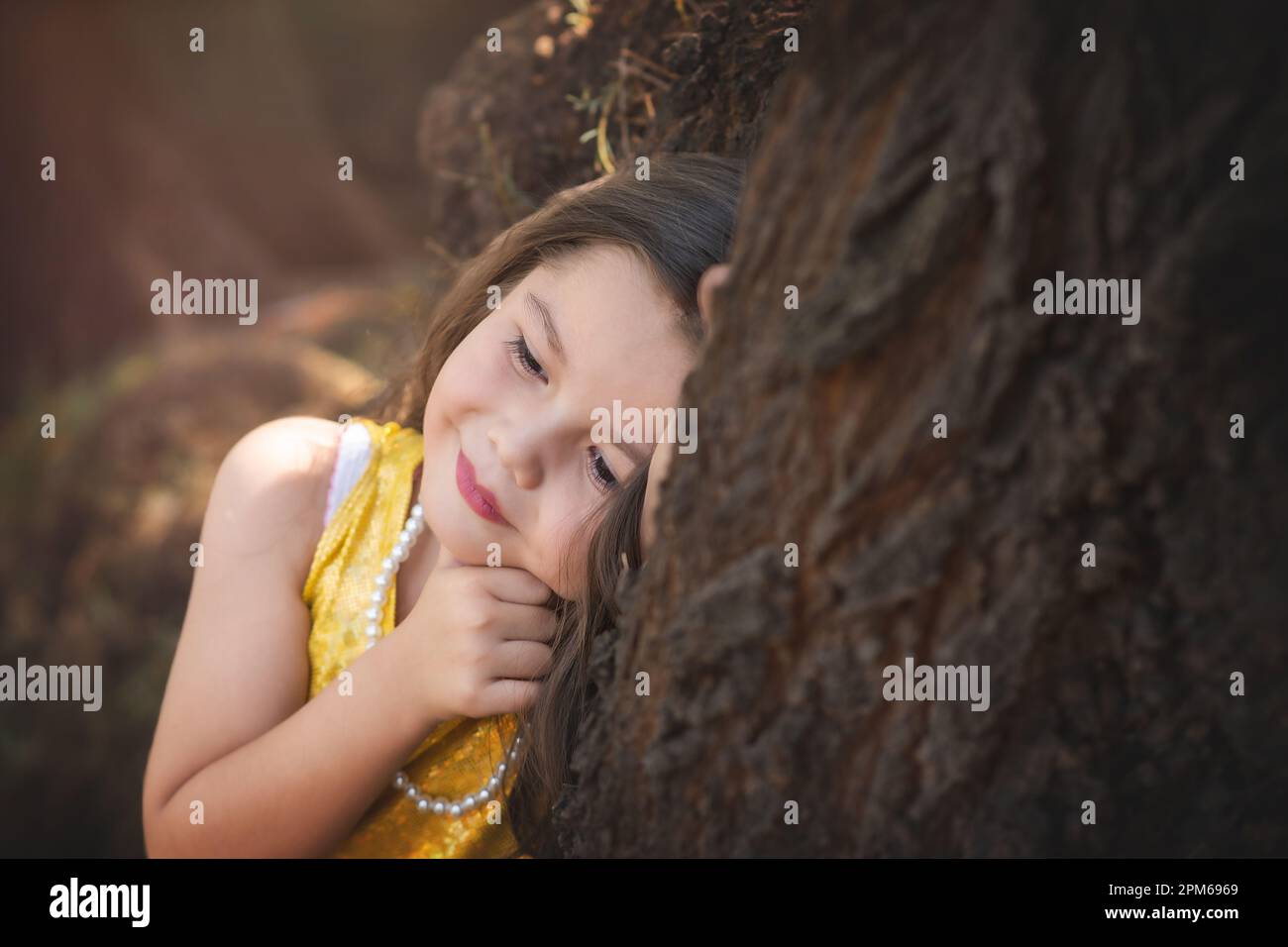 Blonde girl in a photo session posing in a tree. Expressions of ...