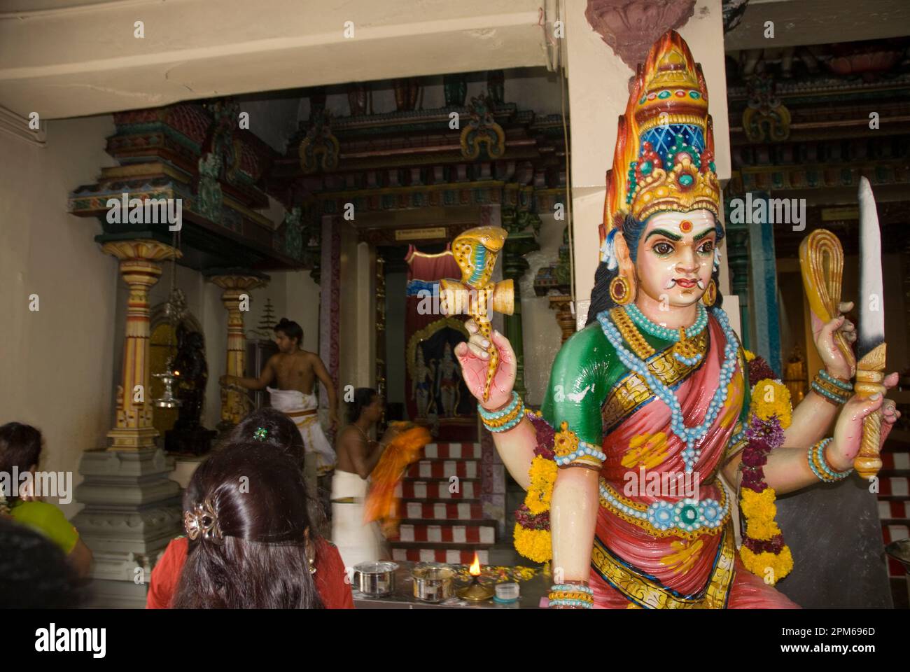 Gaudy statue and priest conducting ceremony for devotees at ceremony ...