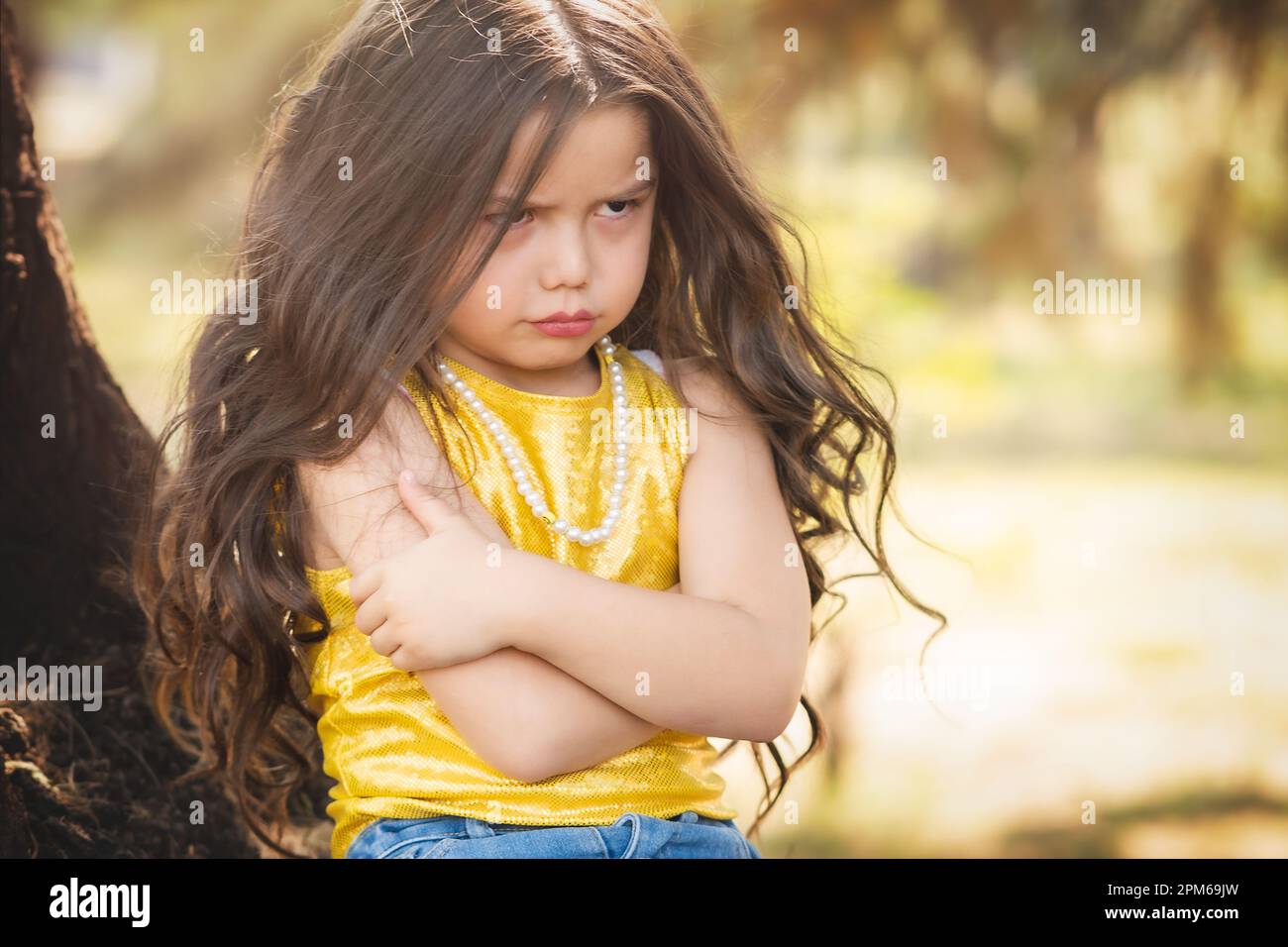 Angry expressions. angry blonde girl sitting in a tree grimacing. model ...