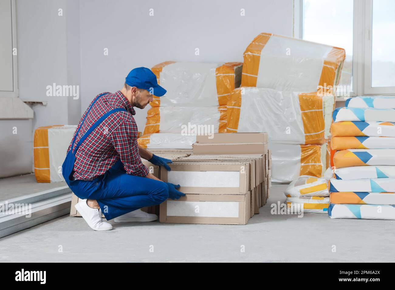 Construction worker with packed new boxes in room prepared for ...
