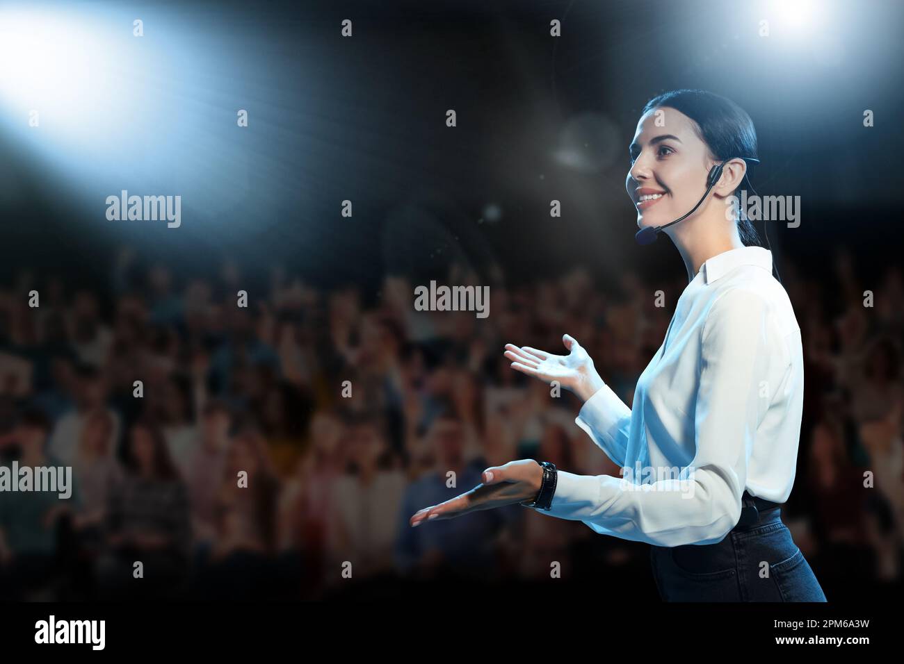 Motivational speaker with headset performing on stage Stock Photo - Alamy