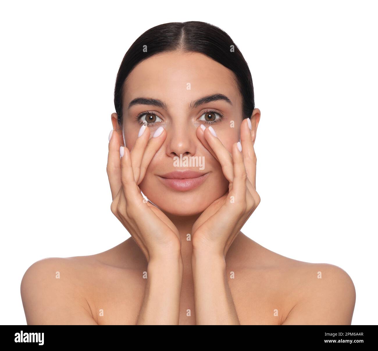 Beautiful young woman touching skin around eyes on white background ...