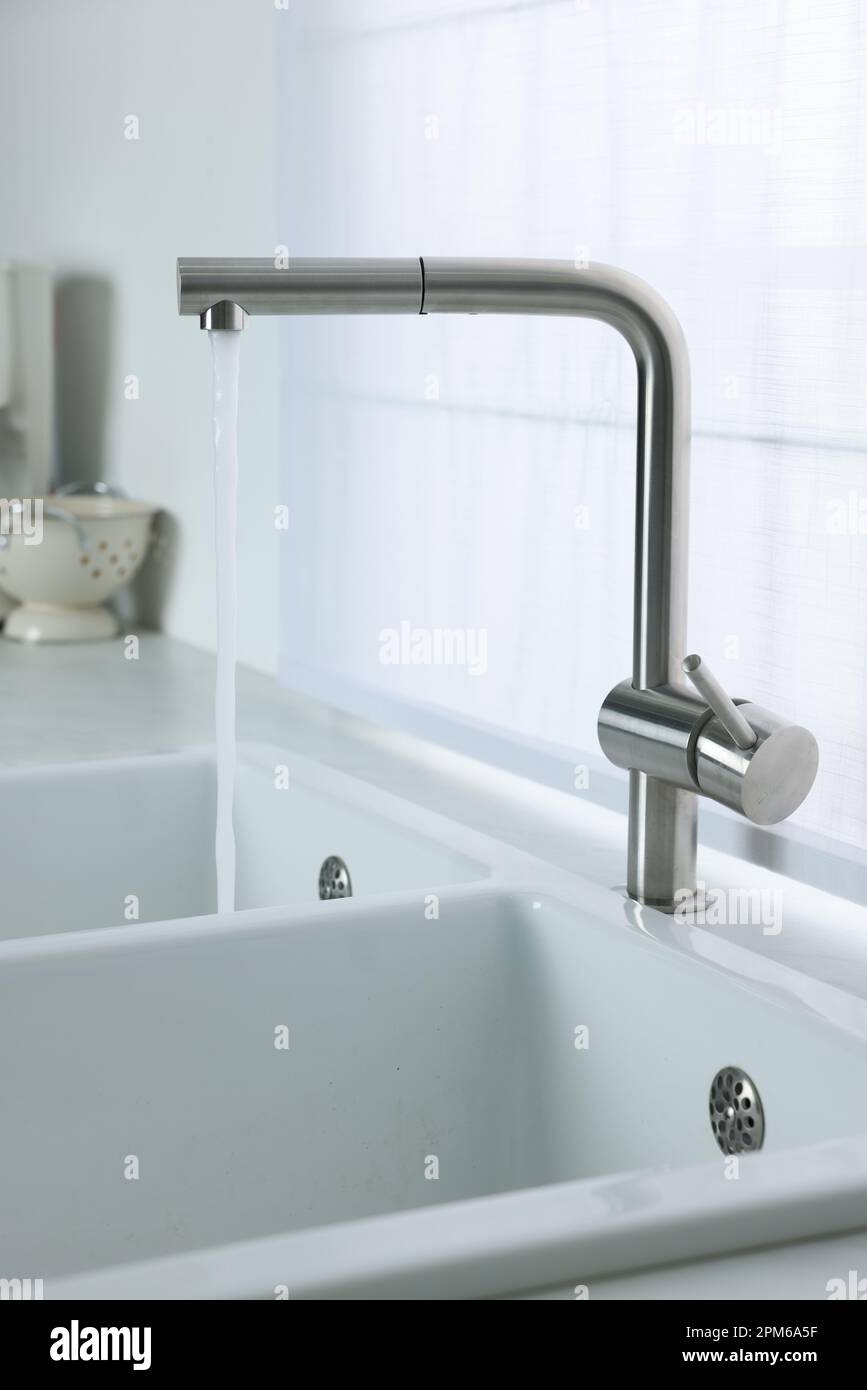 Stream of water flowing from tap in kitchen Stock Photo - Alamy