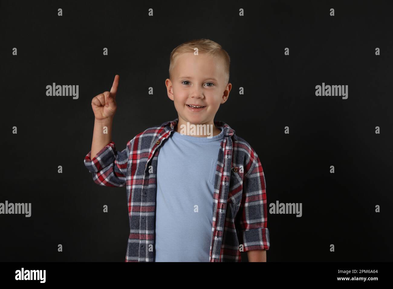 Emotional little boy on black background. Thinking about answer for ...