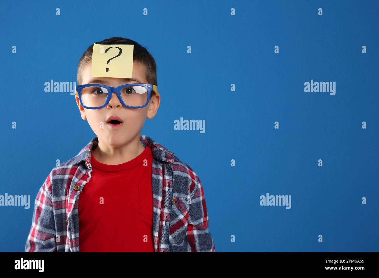 Emotional little boy with question mark on blue background, space for ...