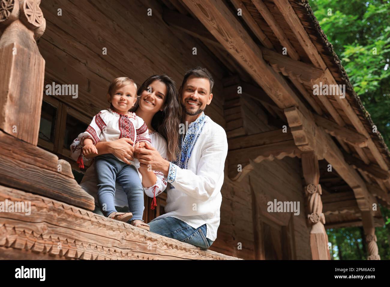 Happy family in Ukrainian national clothes on wooden terrace Stock ...