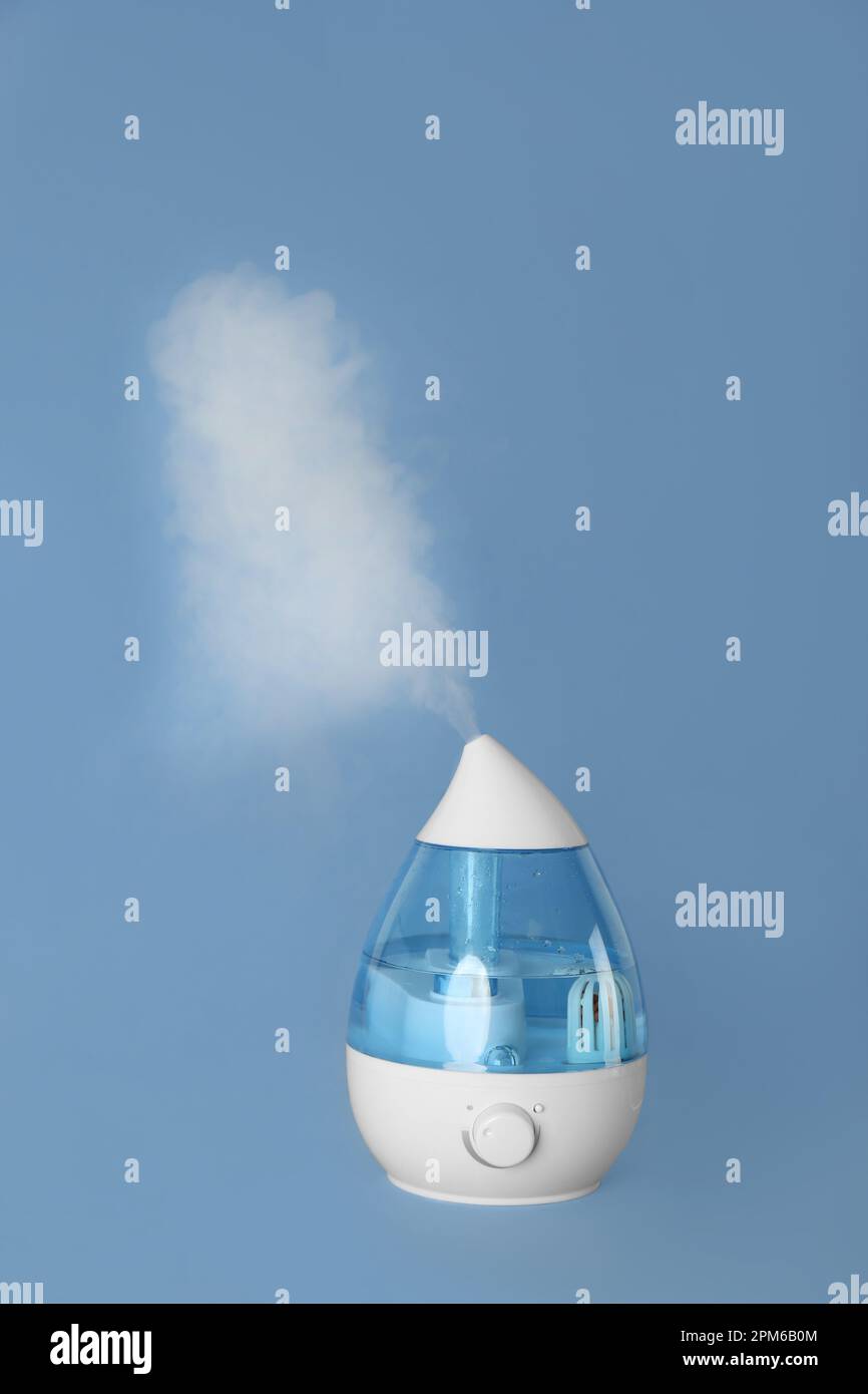 Modern air humidifier on light blue background Stock Photo - Alamy